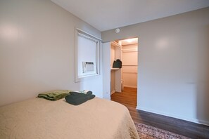 Quarto com uma cama, um armário e corredor que dá para um banheiro.