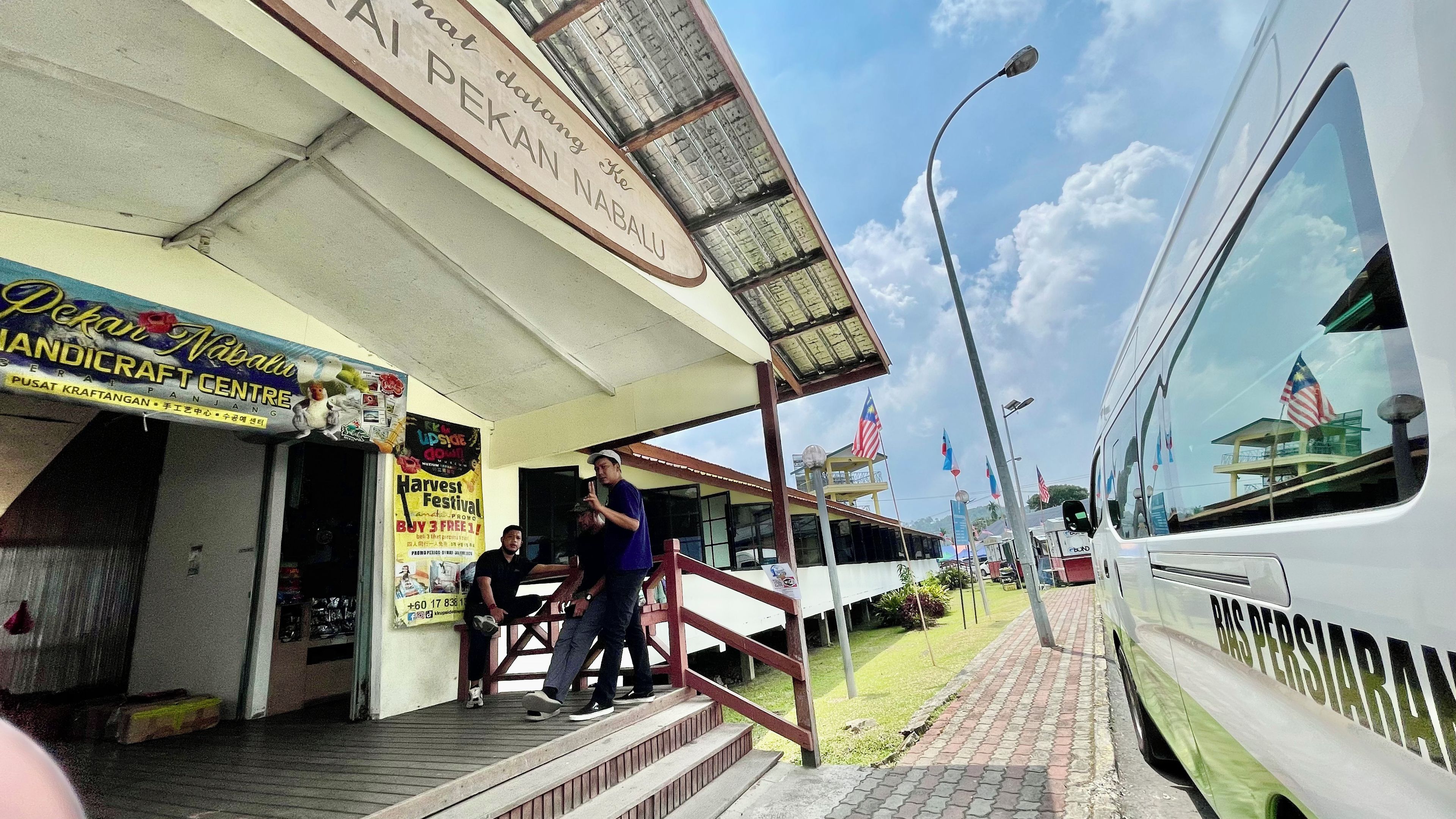 Edifício com placa indicando um centro de artesanato e um ônibus estacionado em frente.