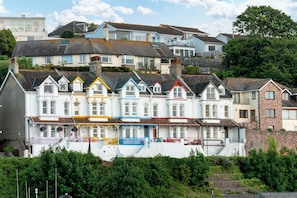 Fileira de casas coloridas em estilo escalonado, com um muro de pedra em primeiro plano.