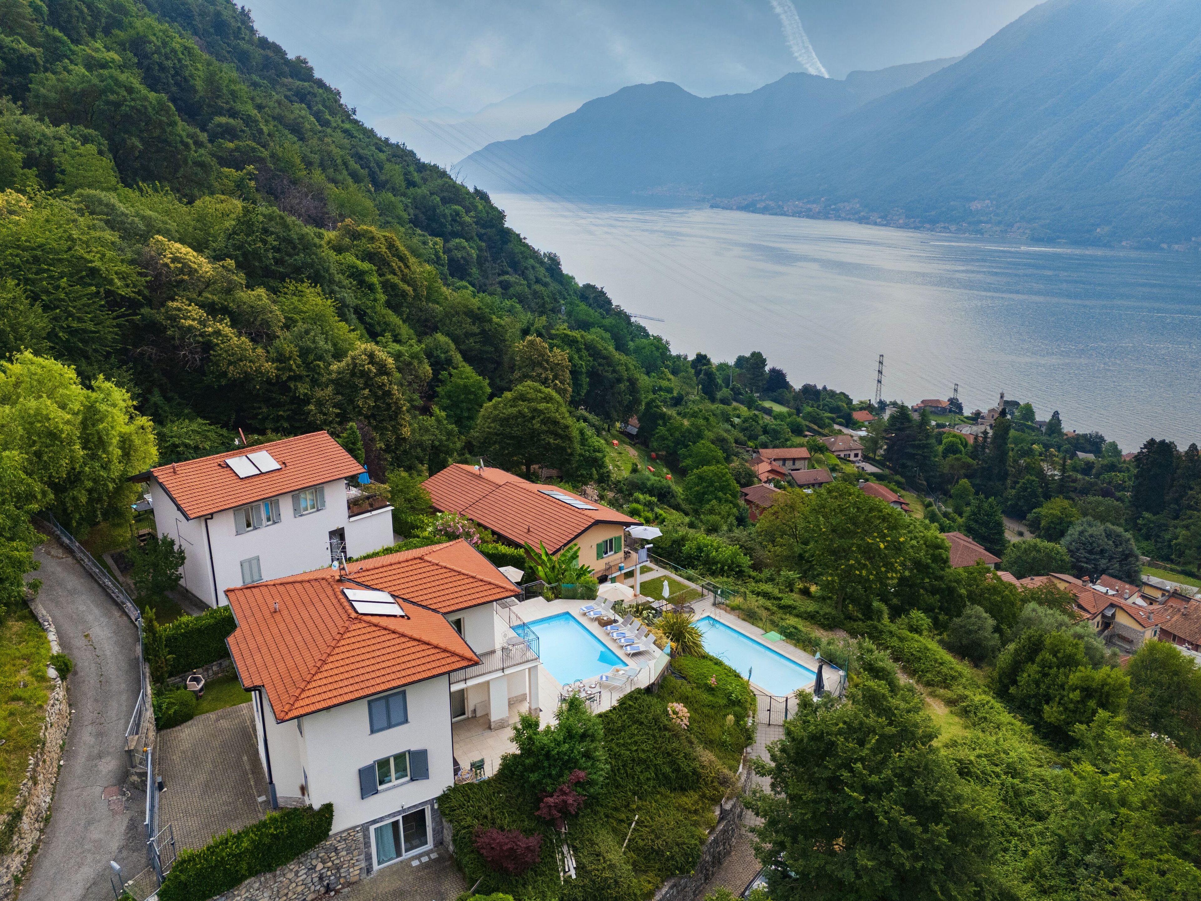 Zona residencial com casas, piscina e um lago ao fundo.