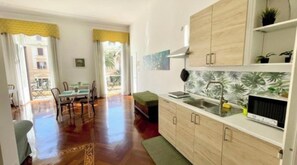 Cozinha moderna com armários de madeira, pia e área de refeições com cadeiras e mesa.