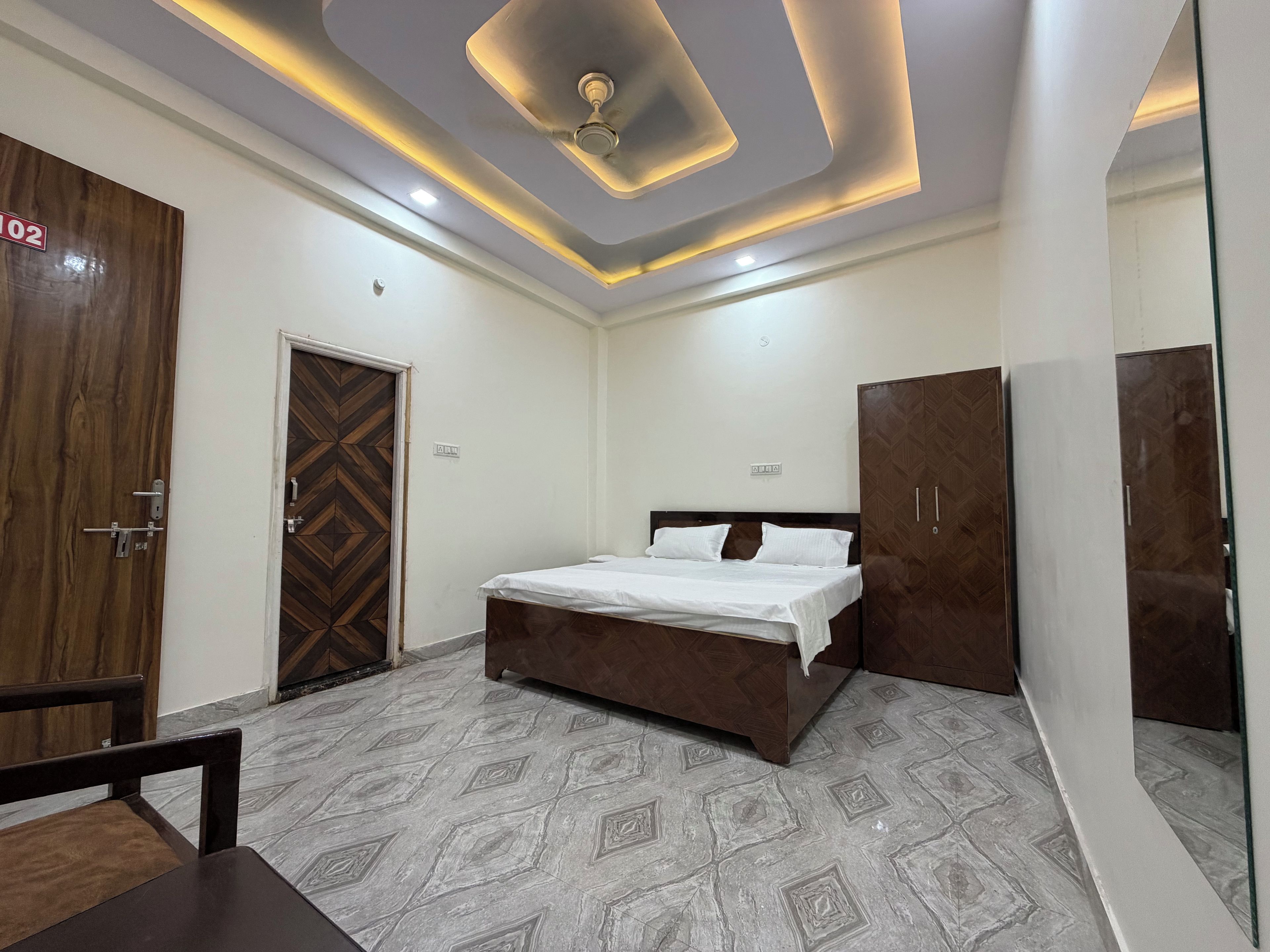 Quarto com cama, guarda-roupa e escrivaninha.