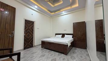 Quarto com cama, guarda-roupa e escrivaninha.