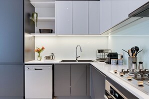 Cozinha moderna equipada com lava-louças, pia e fogão.