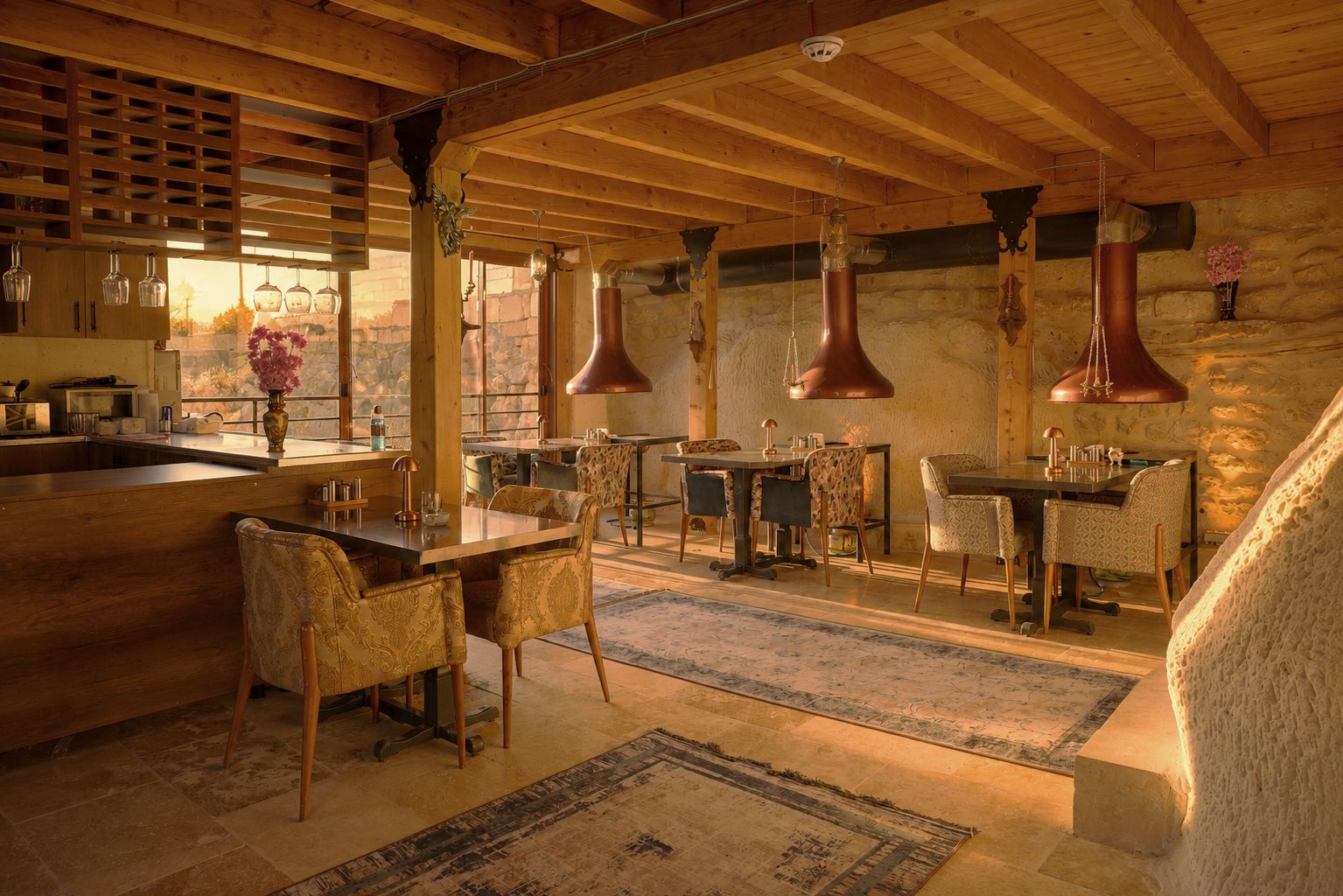 Interior rústico com vigas de madeira aparentes, cozinha e sala de jantar com várias mesas e cadeiras.