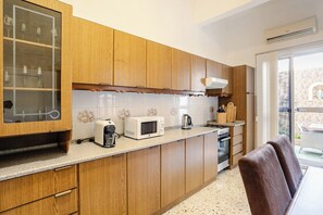 Uma cozinha moderna com armários de madeira, micro-ondas, máquina de café e fogão a gás.