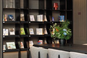 Uma estante com livros e uma planta decorativa.