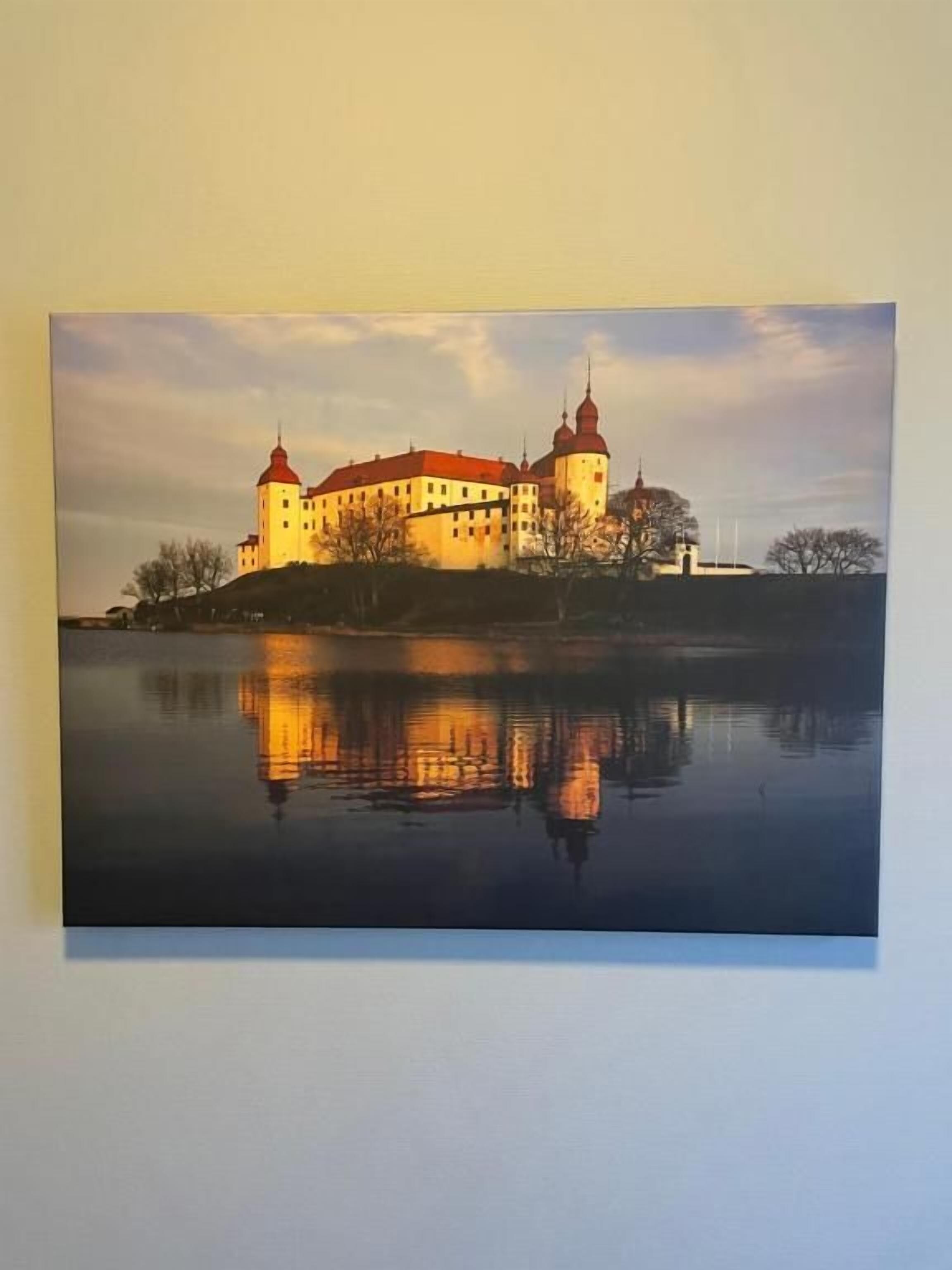 Um edifício que lembra um castelo, com várias torres, localizado à beira de águas calmas.