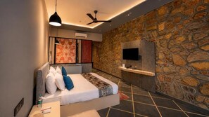 Quarto moderno com parede de pedra, cama com almofadas, mesa de cabeceira, TV de tela plana e ventilador de teto.