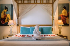 Quarto de hotel com cama, mesa de cabeceira, luminária e um quadro na parede.