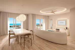 Uma sala de estar moderna com área de jantar, uma janela grande com vista e uma televisão de tela plana na parede.