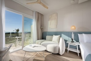 Quarto de hotel moderno com varanda, sofá, mesa pequena e cama.