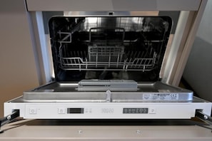 Uma máquina de lavar louça aberta, com painel de controle e uma prateleira interna.