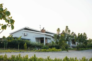 Uma casa moderna de dois andares com telhado plano, antena parabólica e chaminé.
