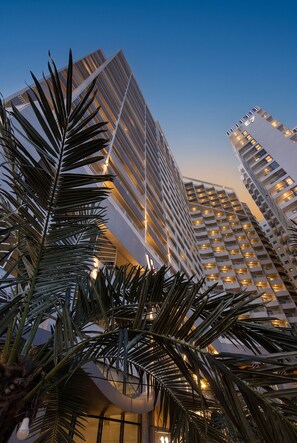 Um edifício alto com vários andares, janelas grandes e design arquitetônico moderno.