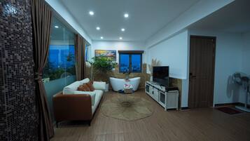 Uma sala de estar moderna com um sofá, uma TV e uma janela grande.