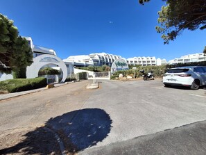 Um edifício moderno com uma placa que diz 'Le Grand Large' e uma motocicleta estacionada em primeiro plano.