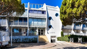 Um edifício moderno com design arquitetônico único, com varandas e uma escadaria que leva à entrada.
