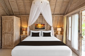 Quarto com cama grande, paredes de madeira, dossel, um quadro e abajures.