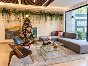 Uma sala de estar moderna com uma árvore de Natal, um sofá e uma mesa de centro.