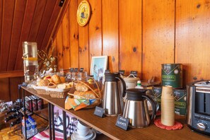 Um buffet de café da manhã com pães, doces, café e chá.