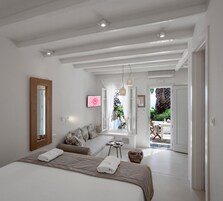 Quarto com uma cama grande, um espelho, televisão e janela vista para o exterior.