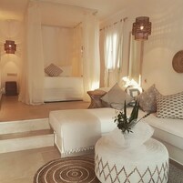 Uma sala de estar moderna com um sofá, um apoio para os pés e um vaso decorativo.