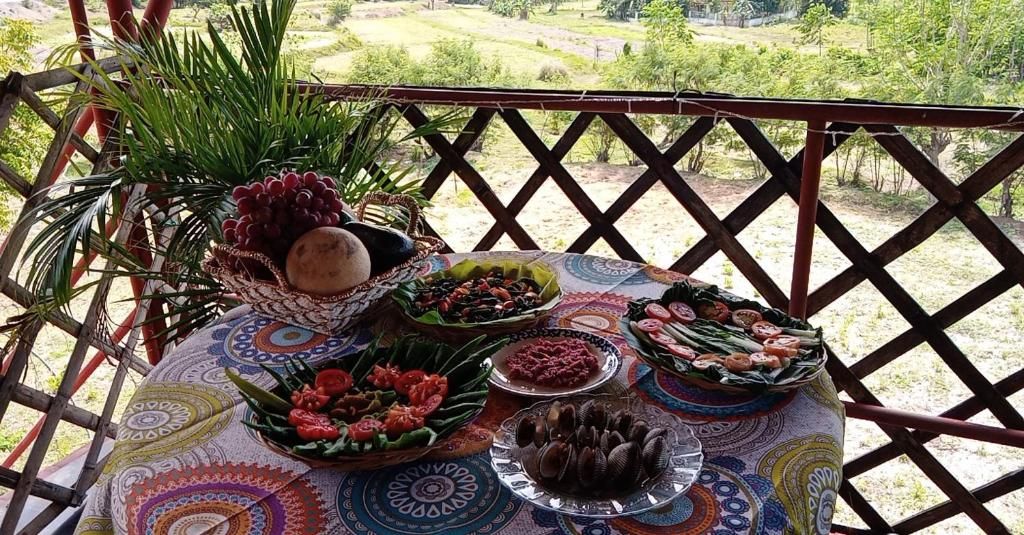 Uma mesa com diversos pratos e vista para uma paisagem rural.
