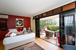 Quarto de hotel com cama, janela com persianas, um quadro na parede e vista para o exterior.