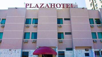 Um edifício com a placa 'PLAZAHOTEL' no topo.