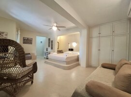 Quarto com cama, cadeira, guarda-roupa e ventoinha no teto.