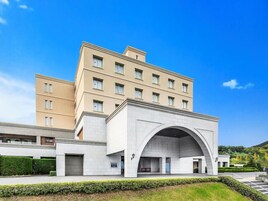 Um hotel de vários andares com uma entrada em arco imponente e um telhado plano.