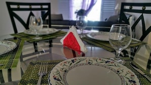Mesa posta com pratos, copos e guardanapo.