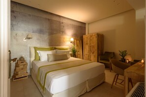 Quarto com uma cama grande, mesas de cabeceira, guarda-roupa, escrivaninha e uma cadeira.