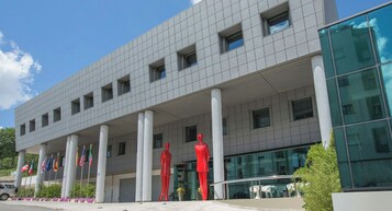Um edifício moderno com telhado plano, janelas amplas e uma série de colunas.