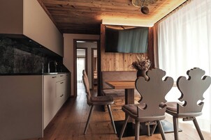 Uma cozinha moderna com armários de madeira e uma área de jantar com mesa e cadeiras de madeira.