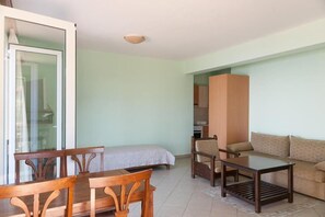 Um quarto com cama, sofá, mesa e cadeira.