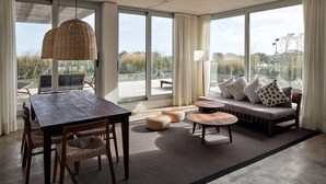 Um interior moderno com uma mesa de jantar, cadeiras, um sofá e um lustre.