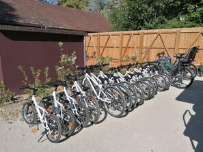 Várias bicicletas encostadas a uma cerca de madeira.