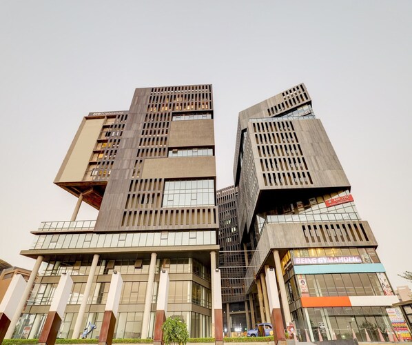 Um edifício moderno de vários andares com um design angular e original, combinando fachadas de vidro e metal.