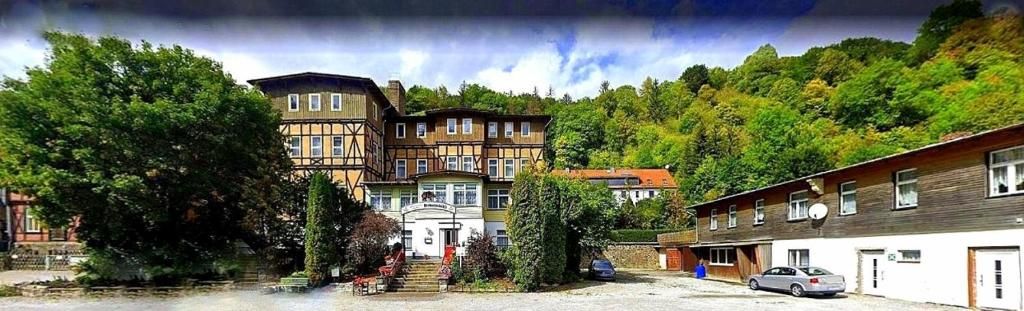 Um edifício europeu tradicional, com vários andares, entrada central e área de estacionamento.