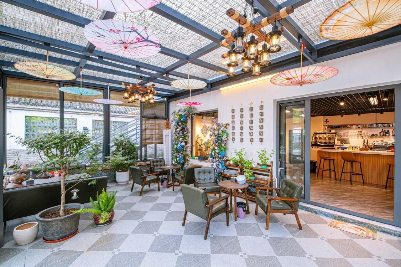 Decoração moderna com piso xadrez, área de estar e cozinha visível por portas de vidro.