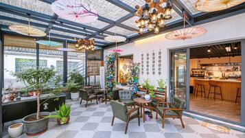 Decoração moderna com piso xadrez, área de estar e cozinha visível por portas de vidro.