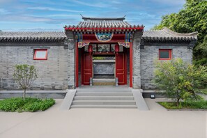 Um edifício tradicional chinês com telhado telhado, portas vermelhas e parede de pedra.