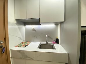 Cozinha compacta com pia, bancada e painel atrás da pia.