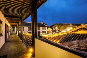 Corredor com arquitetura tradicional, incluindo vigas de madeira e telhados de azulejo.