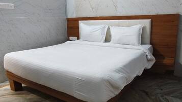 Quarto com cama, cabeceira de madeira, parede de mármore e teto azul.