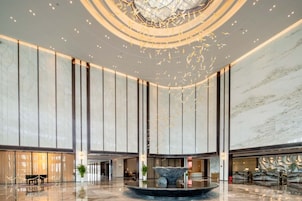 Um hall espaçoso com uma fonte central, pé direito alto e design moderno.