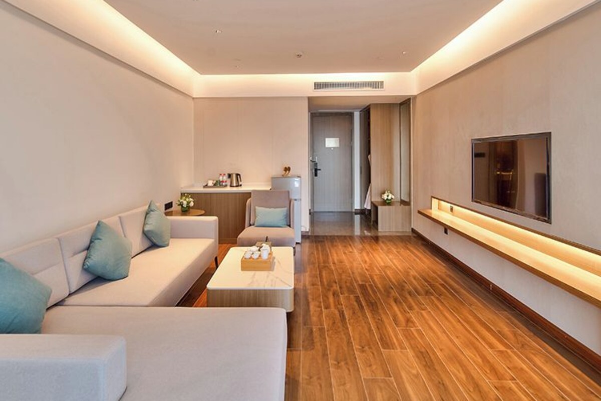 Uma sala de estar moderna com sofá, mesa de centro e TV fixada na parede.