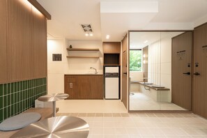 Casa de banho moderna com chuveiro, sanita e lavatório.